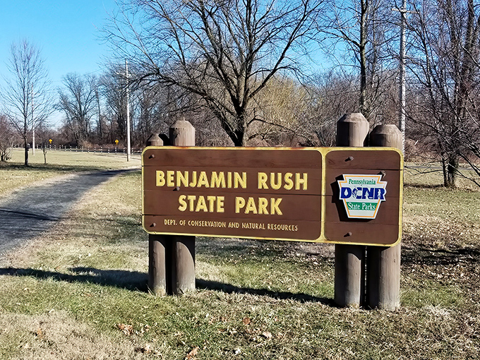 The unassuming entrance to Benjamin Rush State Park stands like a quiet invitation to one of Philadelphia's best-kept natural secrets.
