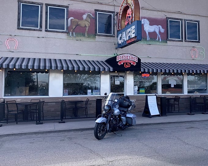 The iconic facade of The Horseshoe welcomes hungry travelers with its charming horse paintings and classic black-and-white striped awning—a beacon of comfort food in Benson.