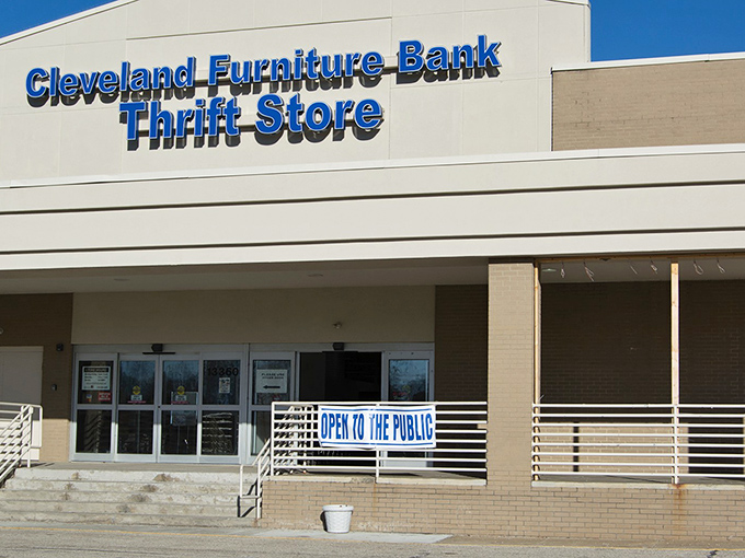 The blue sign beckons like a lighthouse to bargain hunters – Cleveland Furniture Bank Thrift Store, where wallet-friendly treasures await.