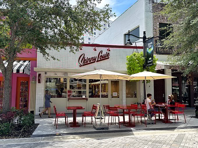 The iconic white-tiled façade with bold red "Skinny Louie" script stands like a beacon of burger hope in Miami's bustling landscape.