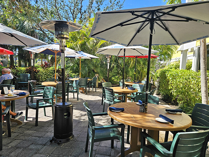 Paradise served al fresco! The outdoor dining area at Lazy Lobster offers umbrella-shaded tables nestled among lush Florida greenery—perfect for enjoying seafood with a side of sunshine.