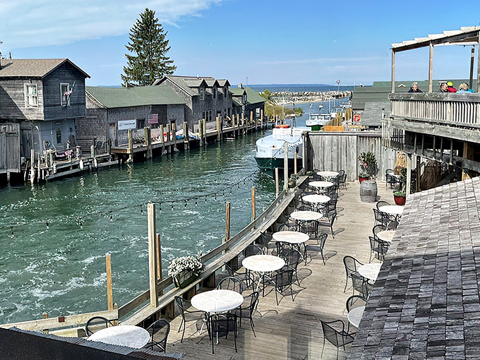 The waterfront deck at The Cove offers front-row seats to Leland's historic Fishtown, where weathered shanties and bobbing boats create Michigan's most charming dining backdrop.