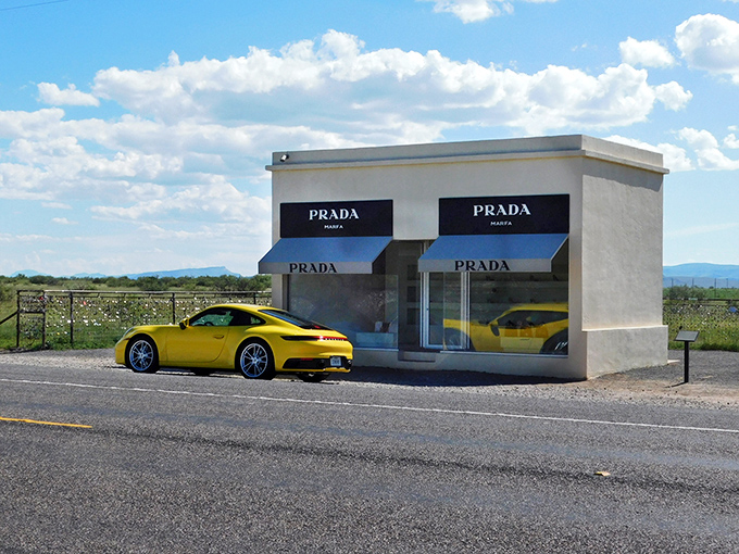 Prada after dark—where high fashion meets high desert under a canopy of stars. The illuminated storefront creates an otherworldly glow against the inky Texas night.