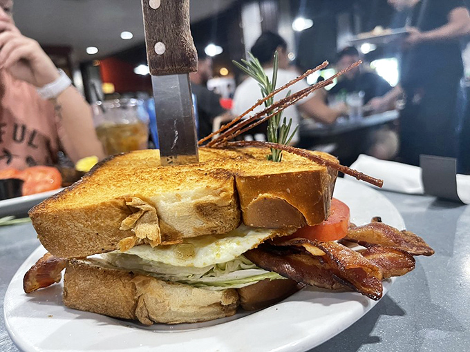 This isn't just a sandwich; it's the Empire State Building of BLTs, complete with a knife standing guard like King Arthur's sword.
