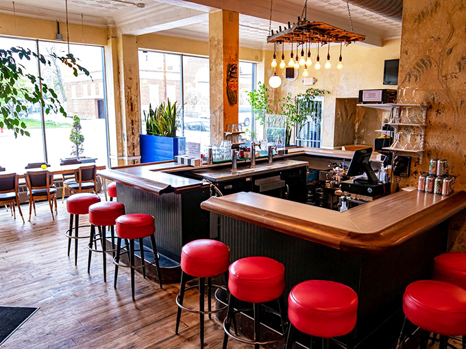 Those cherry-red bar stools aren't just seating—they're front-row tickets to watch mixologists work their magic in a space where mid-century meets modern day.