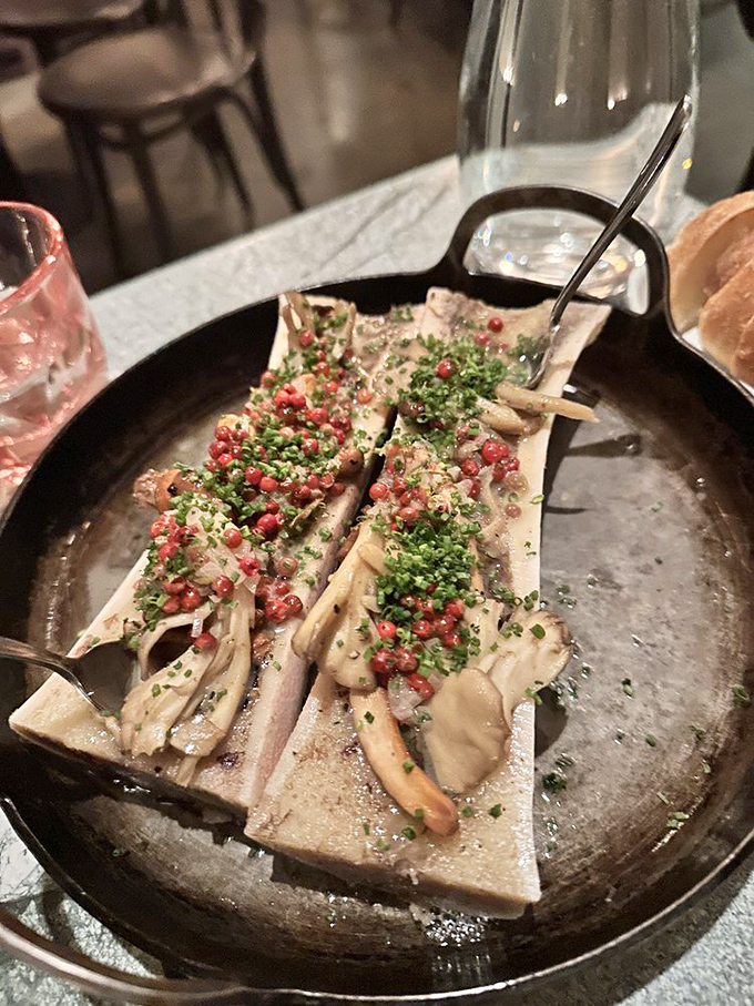 Bone marrow adorned with herbs and pink peppercorns—nature's butter getting the royal treatment it deserves. Decadence you can spread with a spoon.