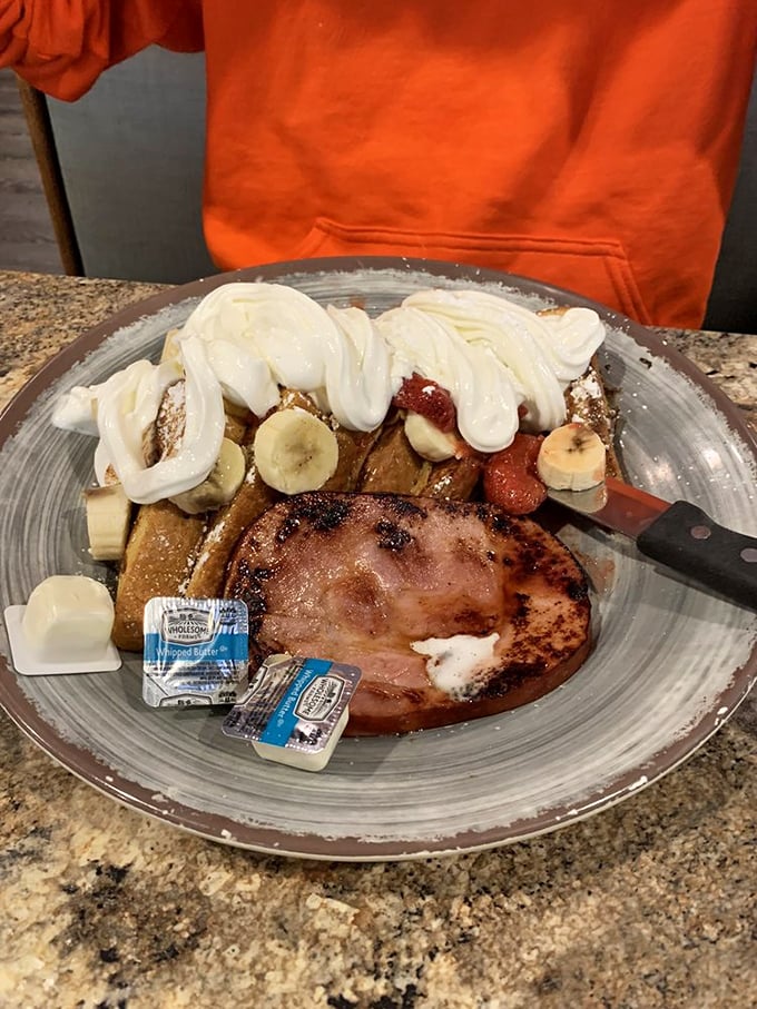 Breakfast nirvana achieved: French toast, ham, eggs, and whipped cream with fruit—the morning equivalent of hitting all green lights on your commute.