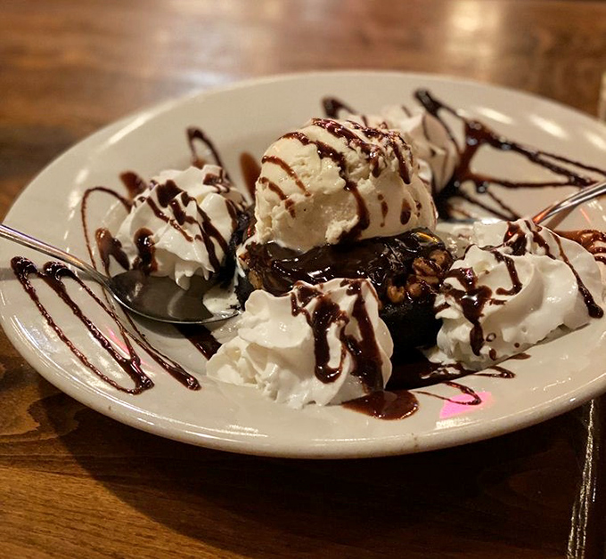 This isn't just dessert; it's a brownie that's having an ice cream party and chocolate sauce shower all at once. Diets beware.