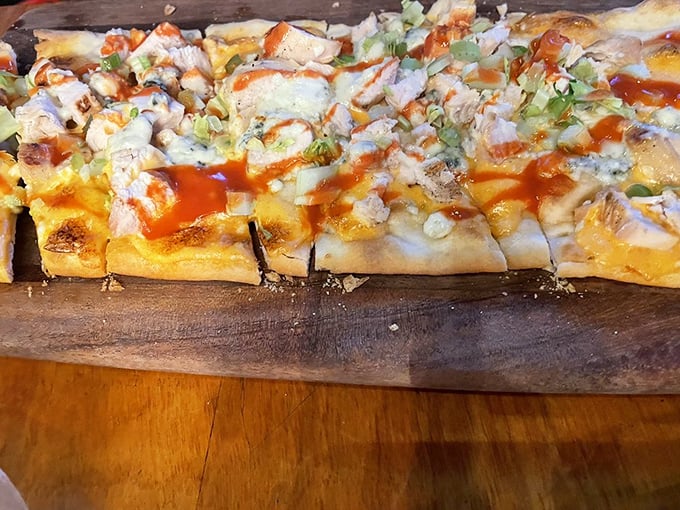 Buffalo chicken flatbread—where crispy crust meets tangy sauce in a flavor marriage that makes you wonder why you'd ever order plain pizza again.
