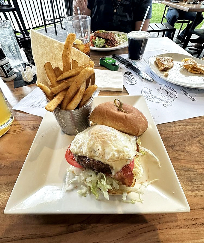 A burger that demands a two-handed commitment, topped with an egg that says "yes, this is definitely going to require extra napkins."