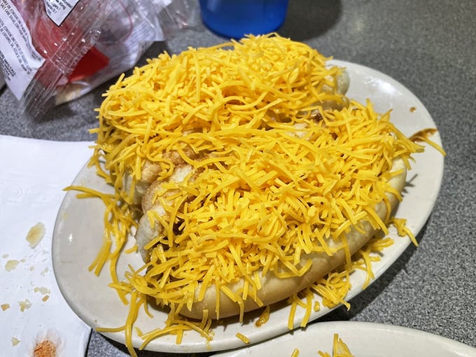 The Cheese Coney in its natural habitat—a hot dog transformed into Cincinnati royalty with chili, cheese, and no pretension.
