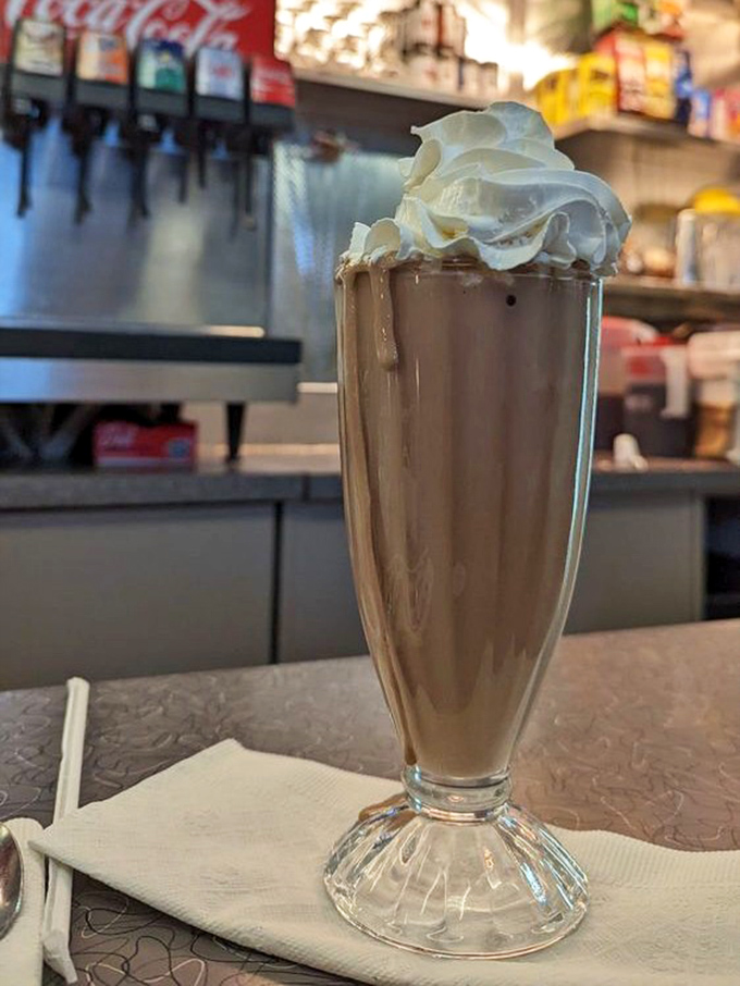 This chocolate milkshake isn't just a drink—it's dessert with a straw. That mountain of whipped cream is practically begging for a selfie.