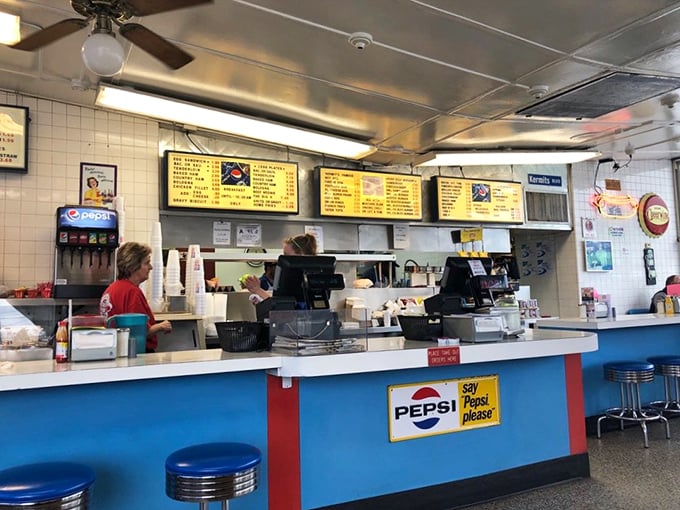 Behind this blue counter, hot dog artisans have been perfecting their craft for decades. No fancy culinary school required—just dedication to the perfect bite.