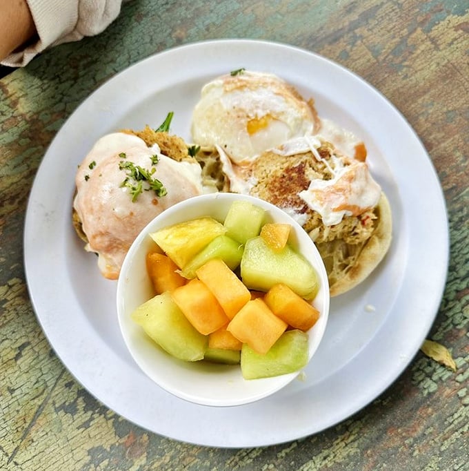 Eggs Benedict gets a coastal makeover with these crab cakes. The fresh fruit cup isn't just healthy—it's strategic planning for more hollandaise.