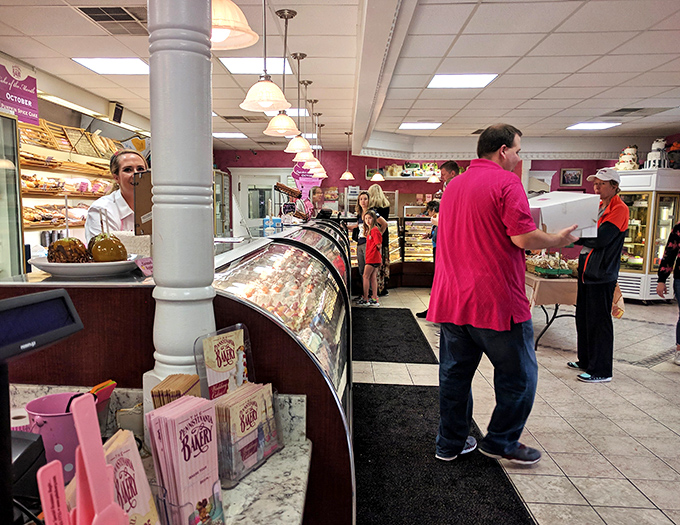 Where dessert dreams come true—customers patiently wait their turn while eyeing the curved display cases filled with edible works of art.