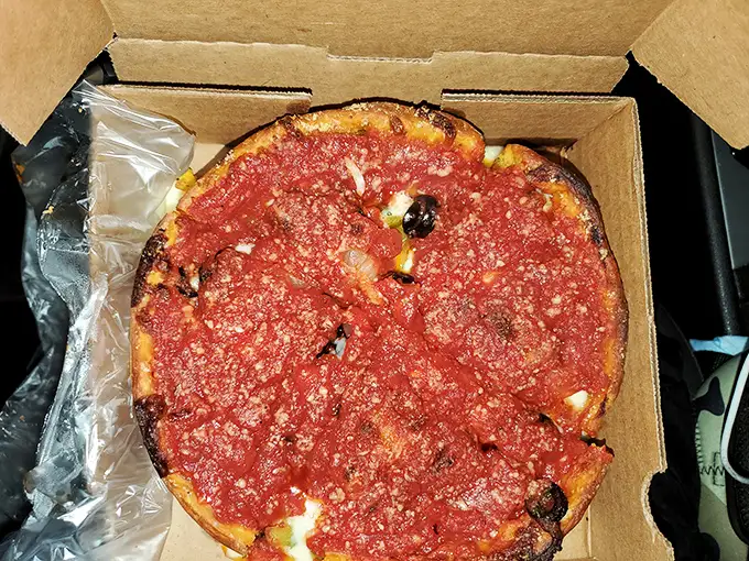 Chicago-style pizza in its natural glory—a deep dish masterpiece where the sauce-to-cheese ratio achieves mathematical perfection.