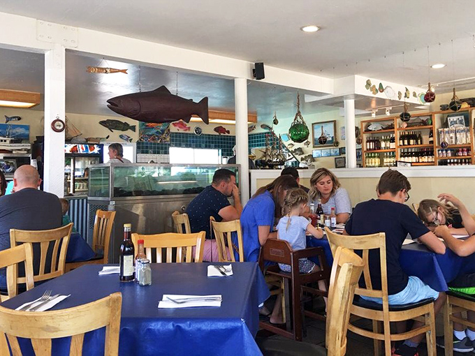 Families gathering around tables, sharing seafood and stories. The blue tablecloths match the ocean these delicacies came from—a thoughtful touch.