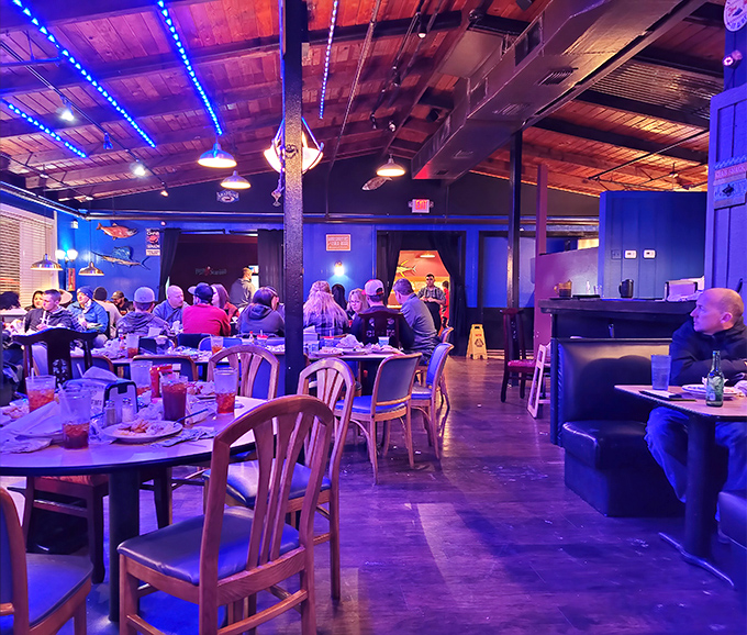Blue lighting transforms dinner into an underwater adventure. These diners aren't just eating—they're participating in an oceanic ritual hundreds of miles inland.