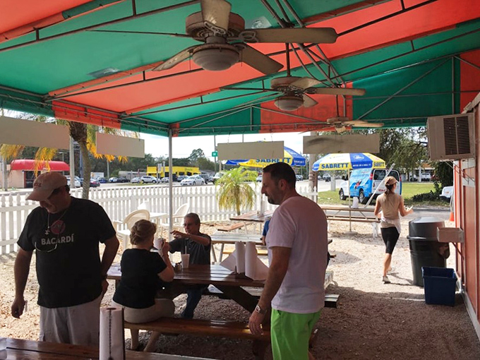 The covered patio brings together strangers united by one noble pursuit—the perfect hot dog experience on a sunny Florida day.