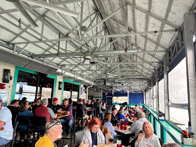 The universal language of contentment: diners lost in conversation and flavors, living their best waterfront life.