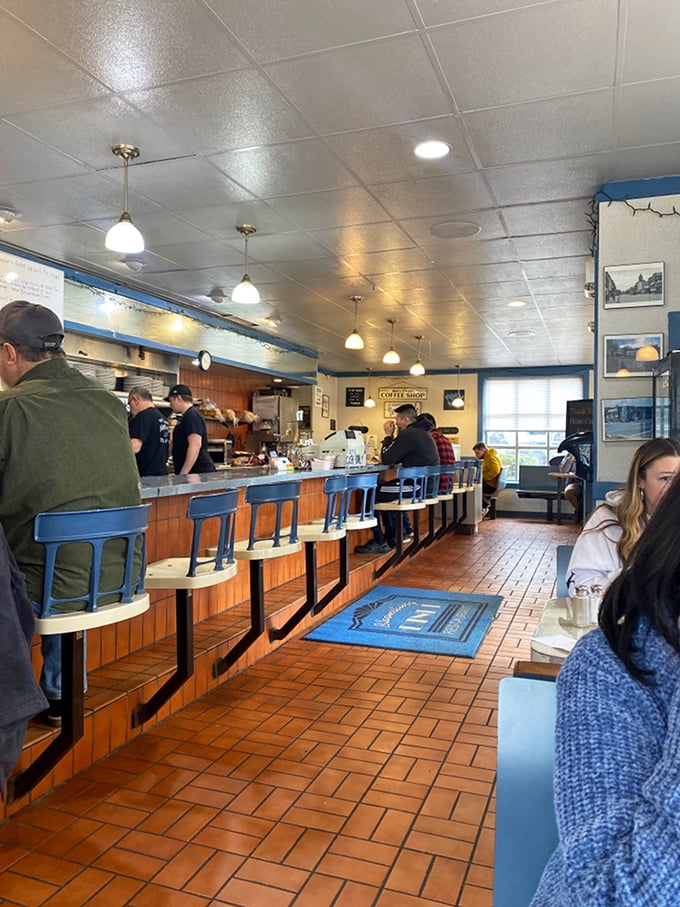 The counter ballet – regulars perched on blue stools watching the morning's choreography of spatulas and coffee pots with appreciative eyes.