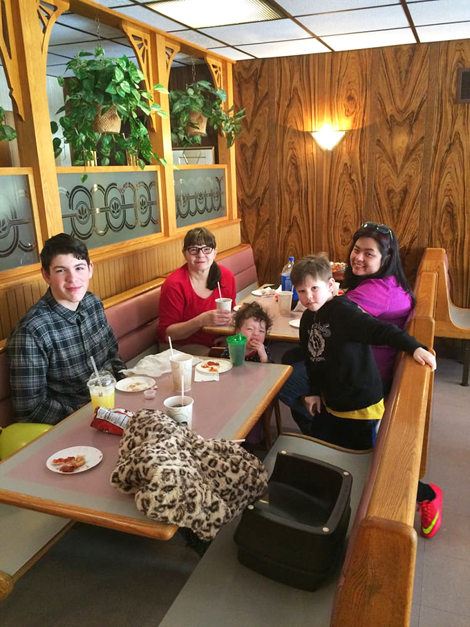 Multi-generational pizza appreciation in action—the universal language of "mmm" transcends age gaps around these tables. 