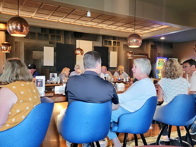 Conversations flow as freely as the cocktails at Cimaroli's bar. The blue chairs aren't just comfortable—they're front-row seats to community in action.