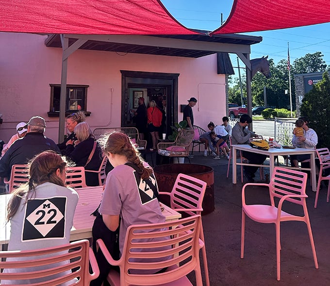 The outdoor patio: where burger enthusiasts gather under crimson shade sails. These pink chairs aren't just functional—they're the perfect pop of color for your Instagram feed and your afternoon.