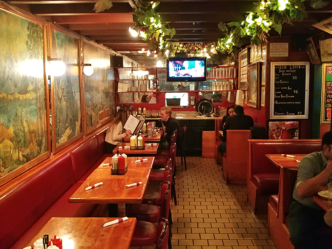 Where strangers become temporary family—this cozy dining space with its murals and hanging vines feels like eating in your eccentric aunt's living room.