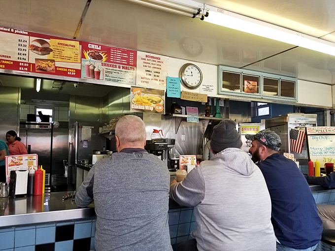 The backs of loyal customers tell a story – this is where regulars come for their burger fix, a ritual as reliable as Michigan seasons.