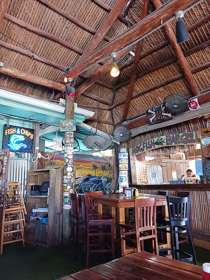 Beneath that thatched roof, magic happens – conversations flow as freely as the drinks while ceiling fans keep the tropical air moving.