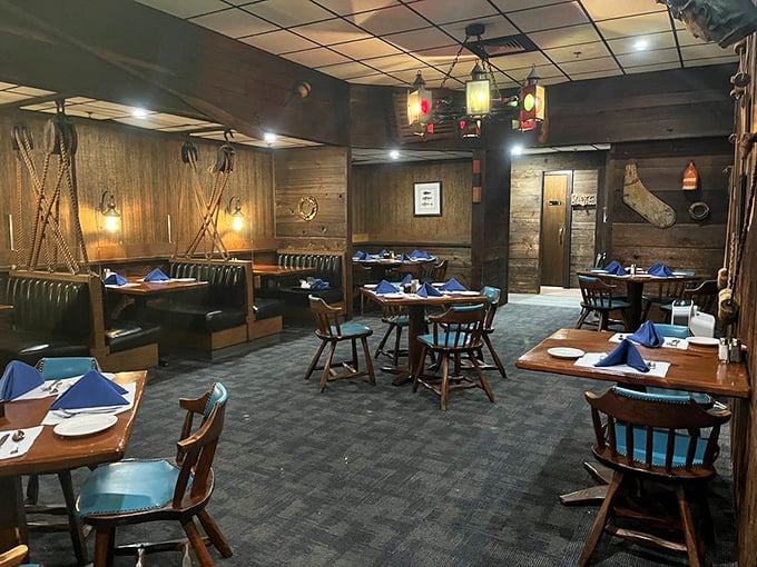 Blue napkins pop against wooden tables in a dining room where every detail whispers "maritime" without shouting "theme restaurant."