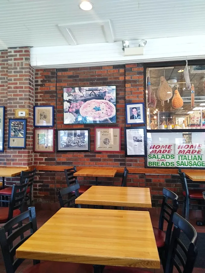 Brick walls lined with framed memories and wooden tables create the perfect backdrop for the main event—that pizza you're about to devour.
