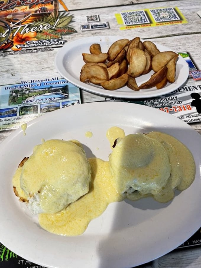 Eggs Benedict with home fries—proof that hollandaise sauce is less a condiment and more a life philosophy worth embracing.