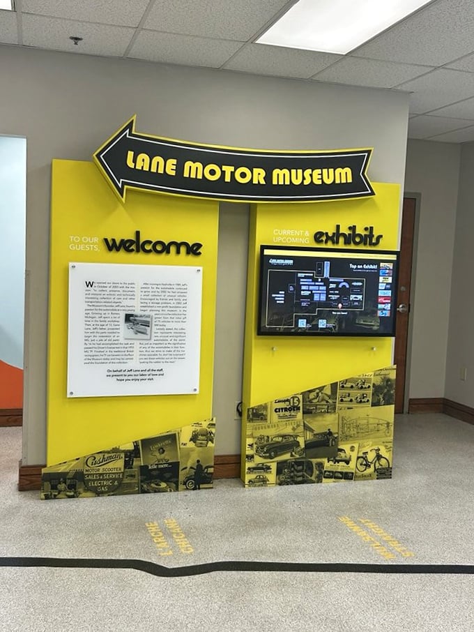 The museum's bright yellow welcome sign points visitors toward automotive adventures. First-timers, prepare for your definition of "car" to be forever changed.