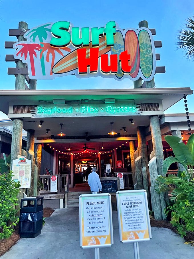 As evening approaches, the neon glow of Surf Hut beckons hungry beachgoers like a lighthouse for the famished.
