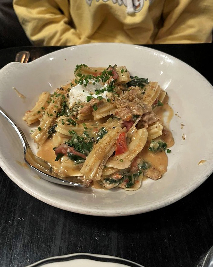 Pasta that doesn't just sit on the plate – it tells a story of fresh herbs, savory sausage, and a sauce worth sopping up with every available bread surface.