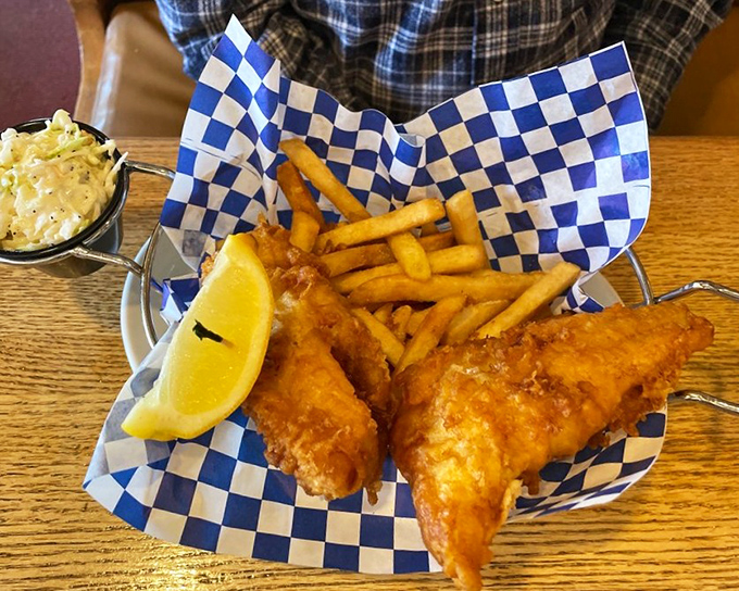 Fish and chips served in a checkered basket—the universal signal that you're about to experience something gloriously unpretentious and deeply satisfying.