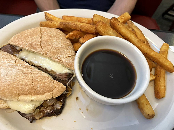 The French Dip—where thinly sliced beef meets melted cheese on pillowy bread with a side of au jus for necessary dipping adventures. 