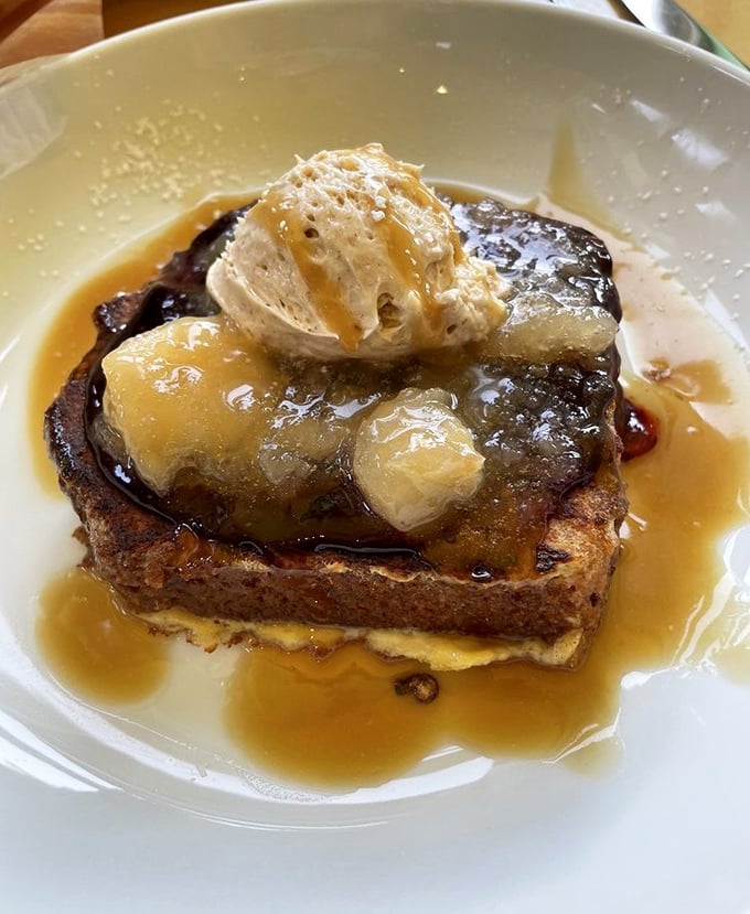 French toast that's transcended its humble origins—caramelized, topped with fruit, and swimming in syrup like it's taking a delicious spa day.