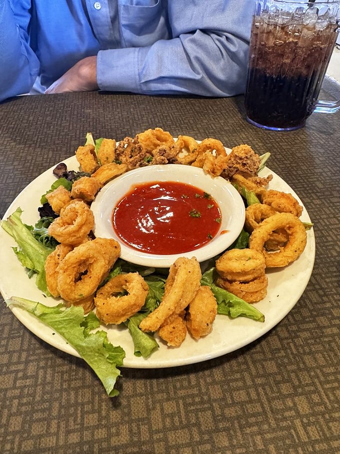 Crispy calamari rings surround their dipping sauce like a delicious golden moat protecting a castle of marinara treasure.