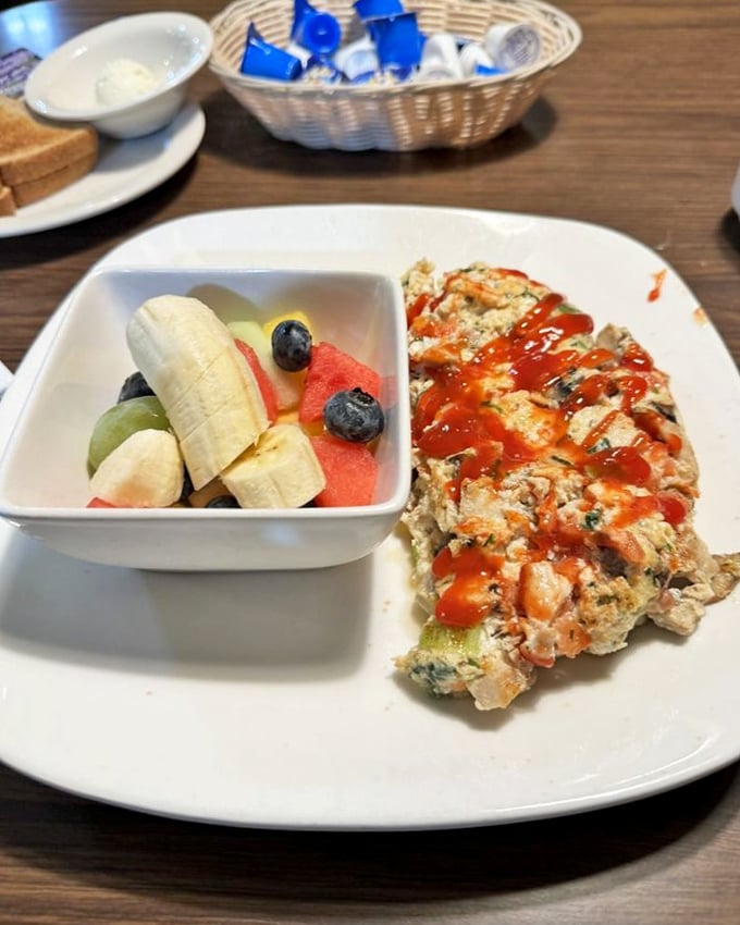 Healthy meets hearty with this protein-packed omelet served alongside fresh fruit—proof that "nutritious" and "delicious" aren't mutually exclusive concepts.