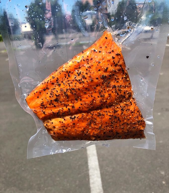 That vacuum-sealed packet contains what might be the world's most perfect road trip snack – pepper-crusted smoked salmon that makes gas station beef jerky weep with inadequacy.
