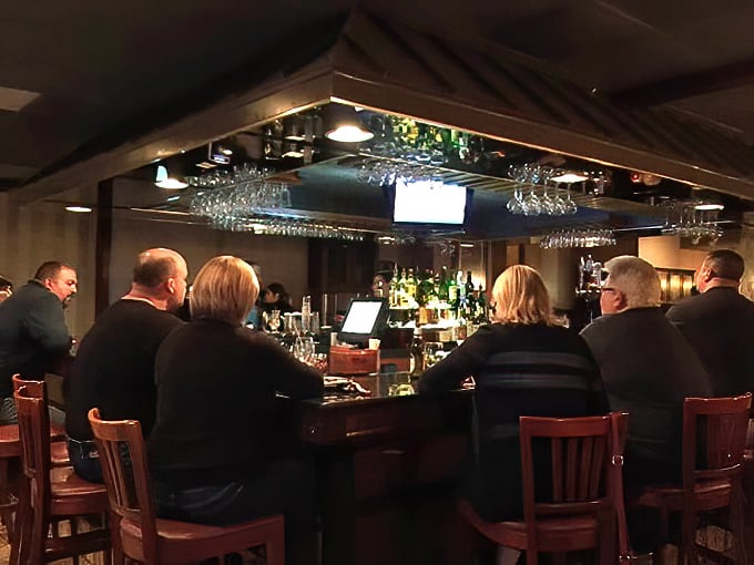 Another angle of the bar reveals the heart of Café Rinaldi's social scene, where martini glasses clink and pizza debates rage on.