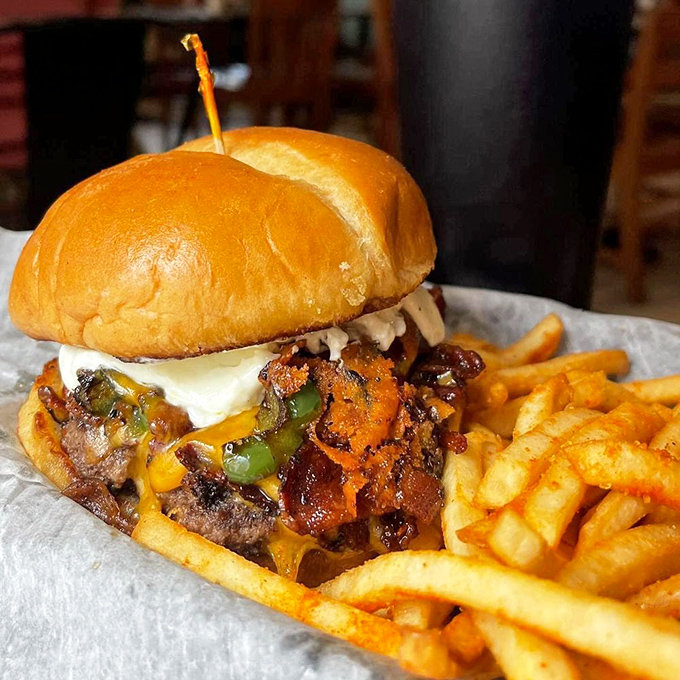 This burger doesn't just have toppings—it has ambitions. Melted cheese cascading over bacon and peppers like a delicious waterfall.
