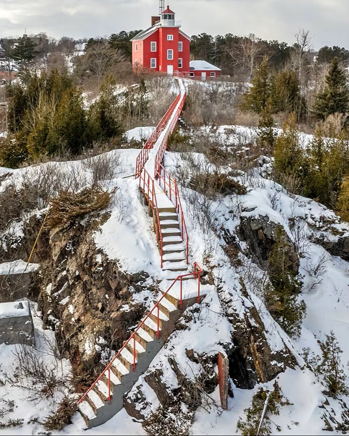 The red lighthouse perched dramatically above snow-covered cliffs seems to say, "Yes, the climb is worth it"—and the view proves it right.