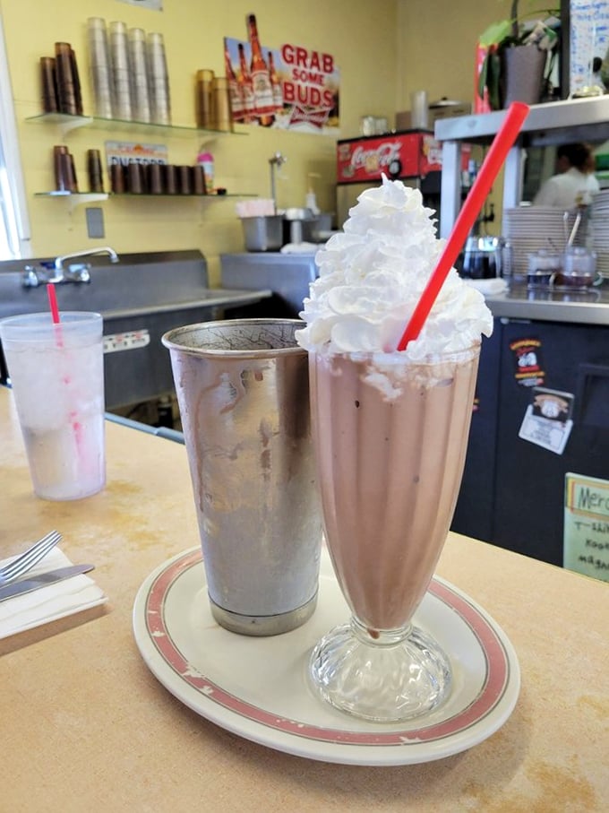 Milkshakes served in glasses that remember when Elvis was king. That whipped cream mountain on top isn't just decoration—it's a dairy Everest.