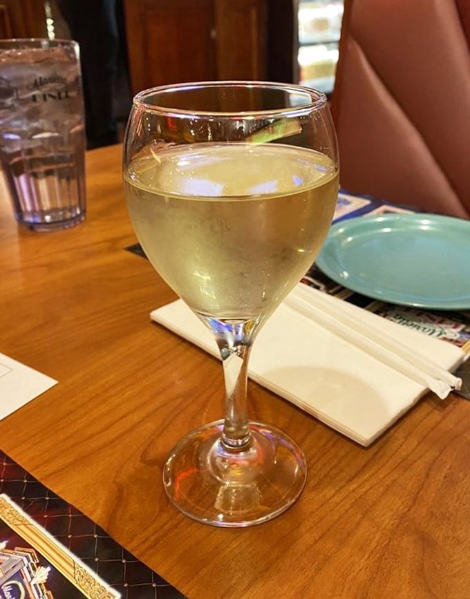 A glass of chilled Moscato sits ready to complement your feast—because sometimes adulting means pairing wine with your diner splurge.