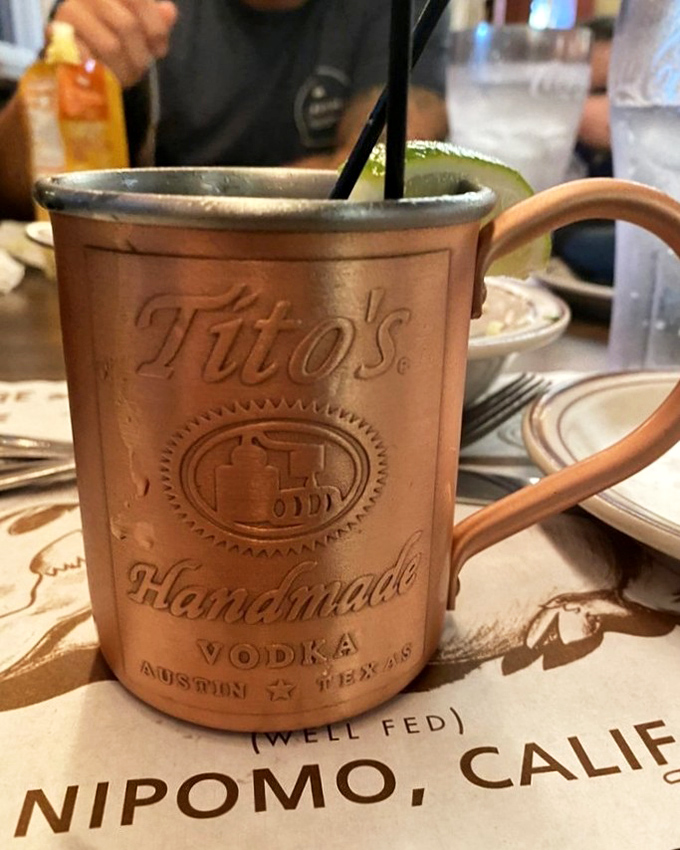 A Moscow Mule that means business, served in a copper mug that's seen things. Those cherries aren't garnish—they're the reward at the bottom of the glass.