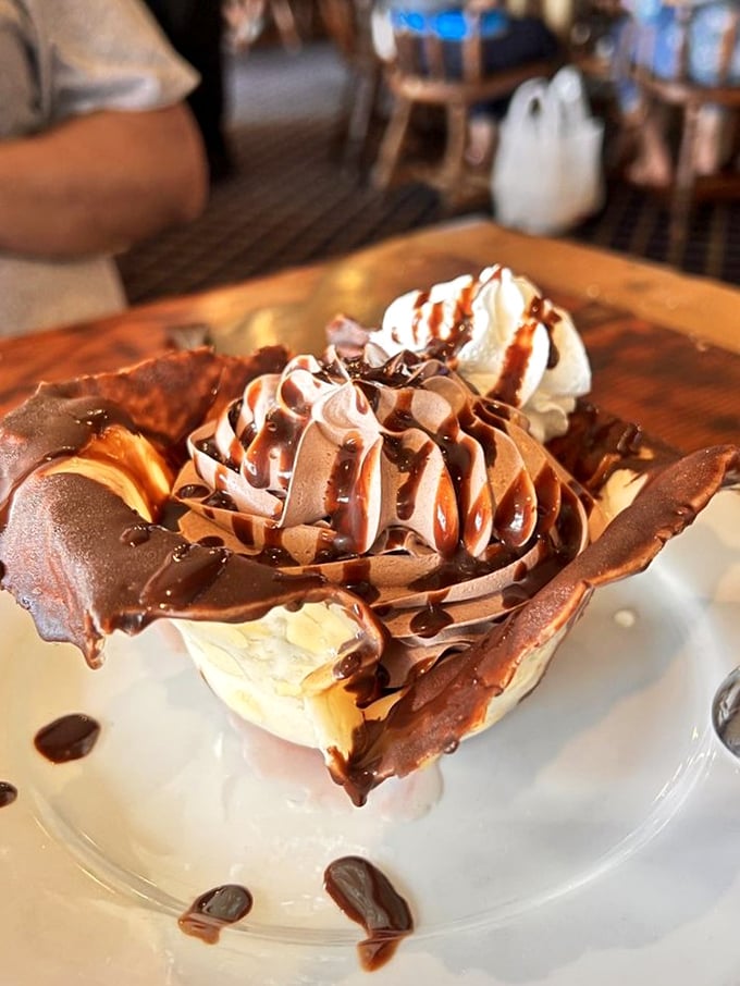 This isn't just dessert, it's architecture—chocolate mousse cradled in a delicate almond brittle shell that deserves its own episode on HGTV.
